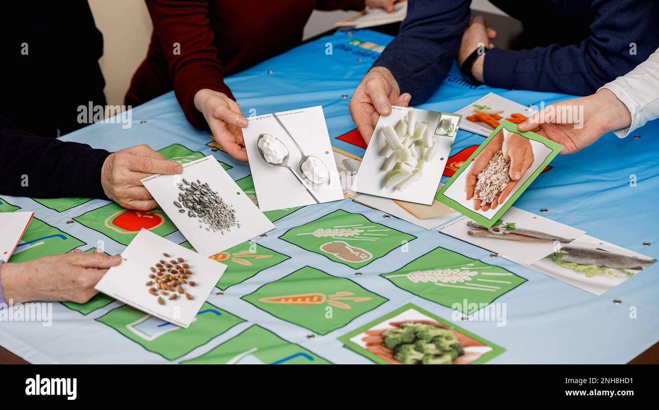 A group of people hold cards with pictures of healthy eating. Healthy ...