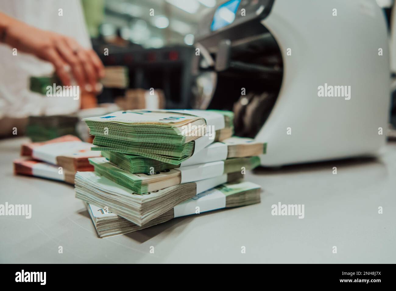 Bank employees using money counting machine while sorting and counting ...