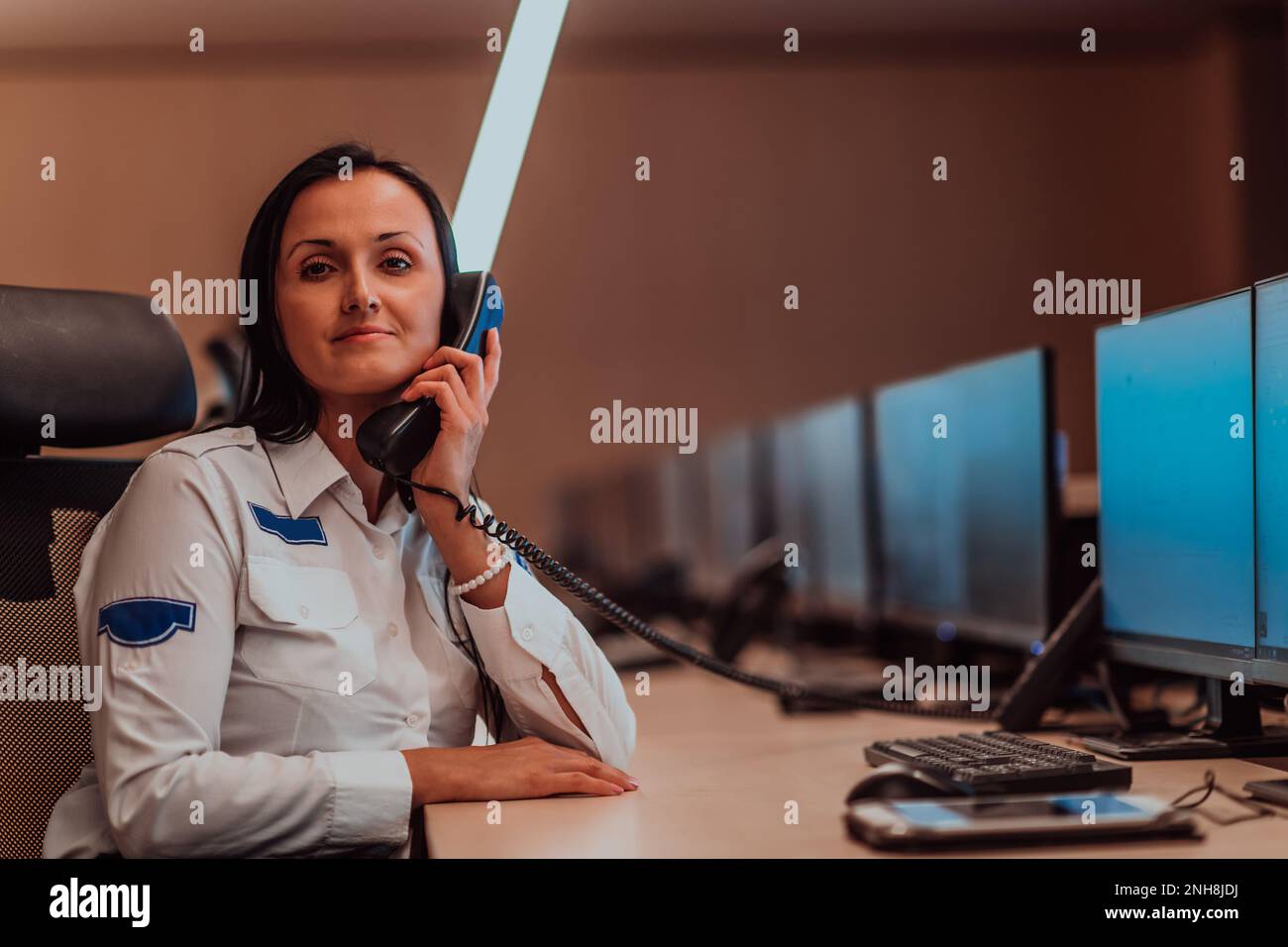 Female security operator working in a data system control room offices ...