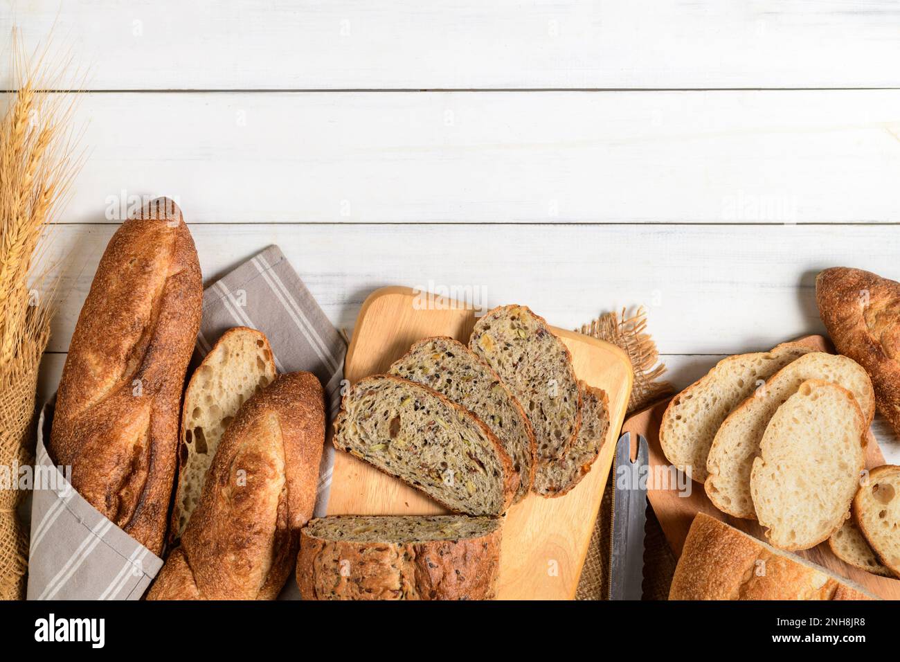 slide multi grain sourdough bread and sliced Baguette on white wood ...