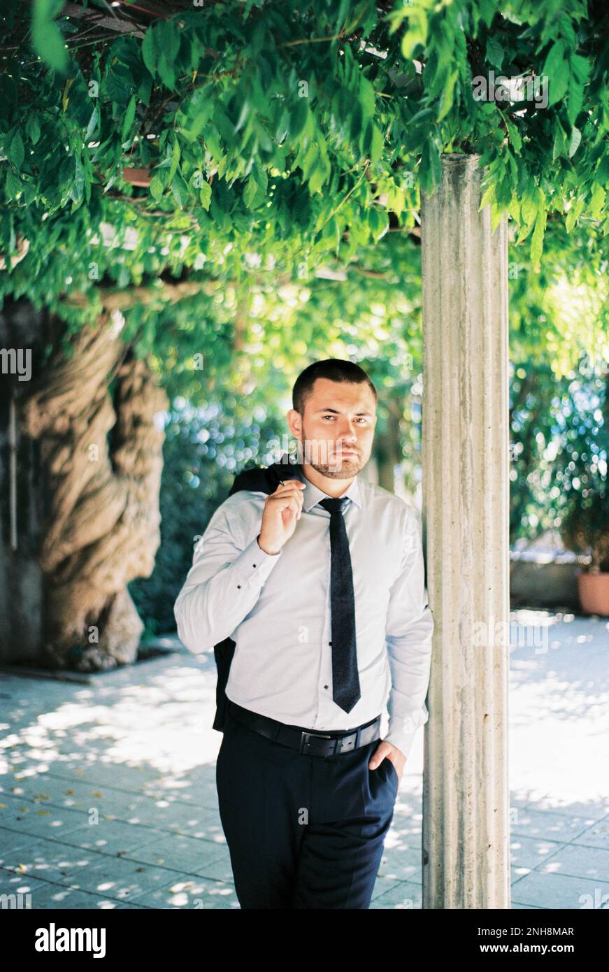 Dobrota, Montenegro - 06.06.21: Man in a suit with a jacket over his ...