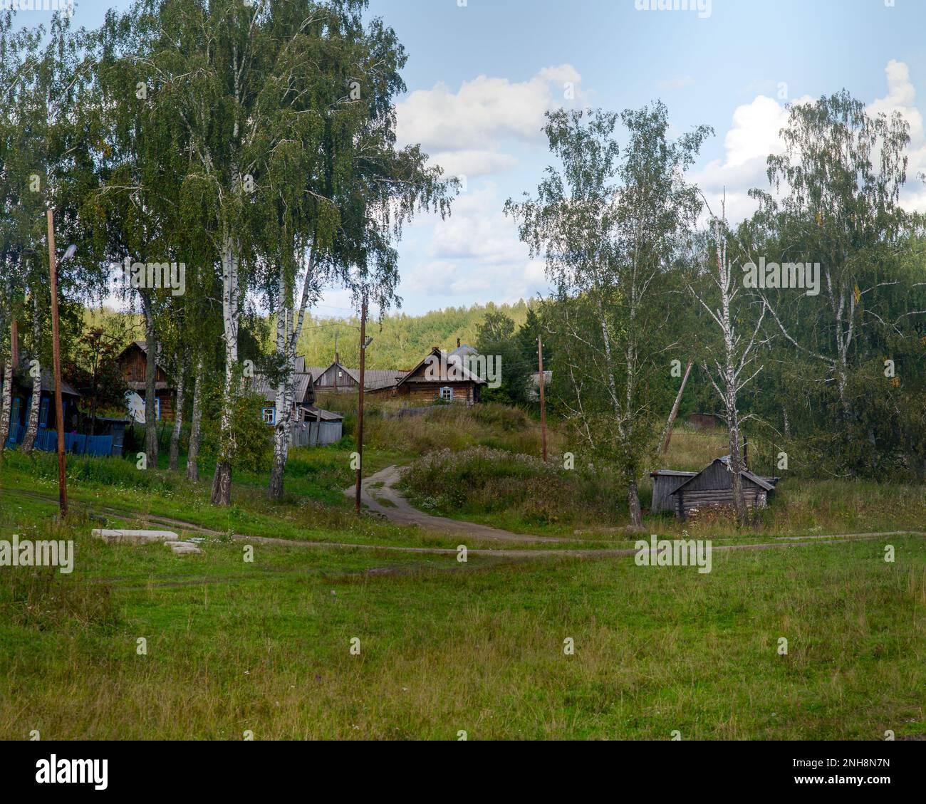 Siberian village landscape with a turn of rural road at the slides with ...