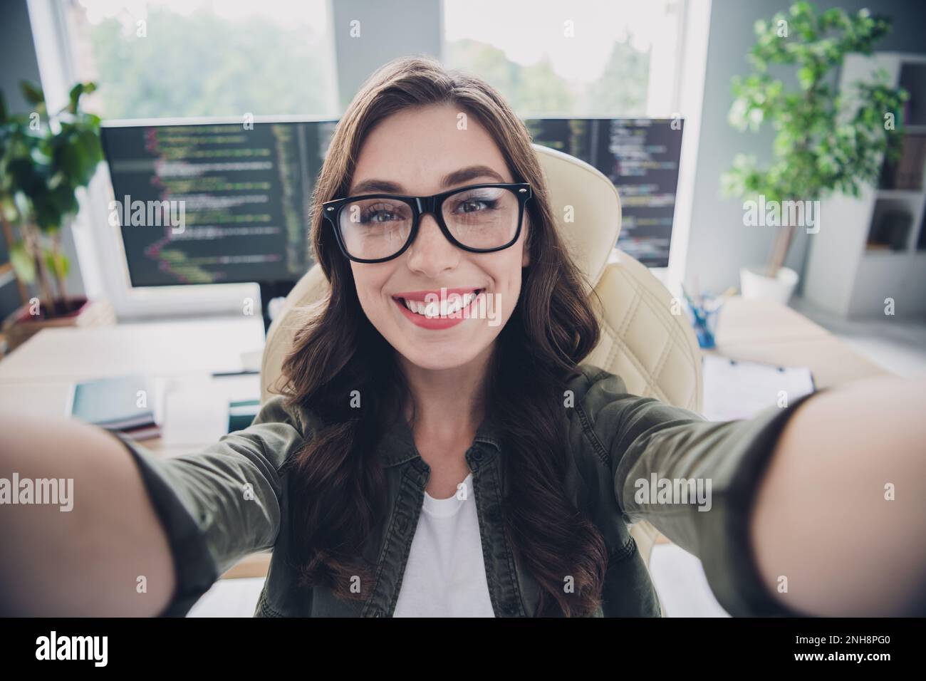Photo of charming cheerful lady programmer wear eyeglasses recording working vlog indoors ...