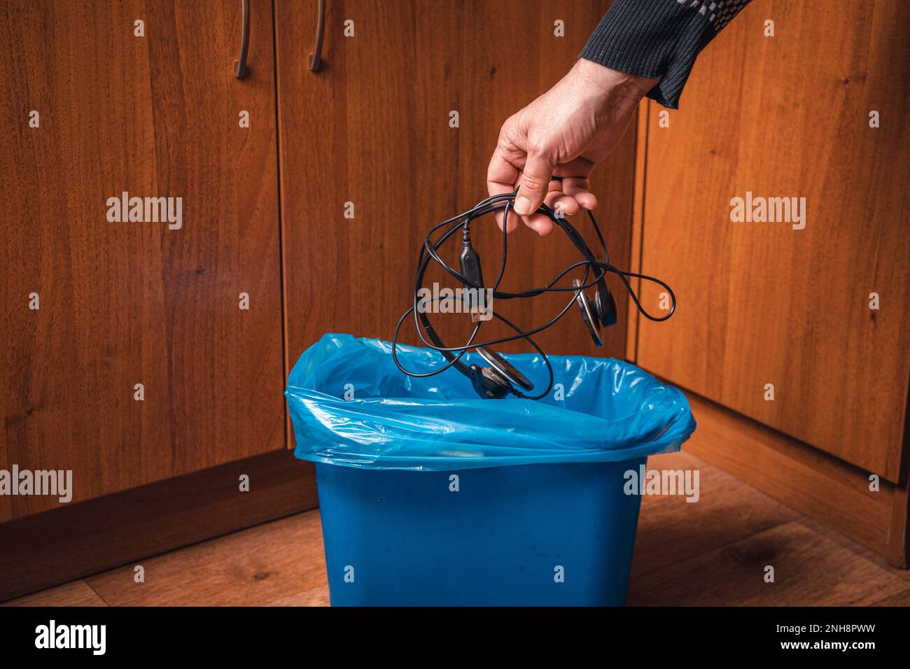 The man throws the headphones in the trash. Male hand with old wired ...