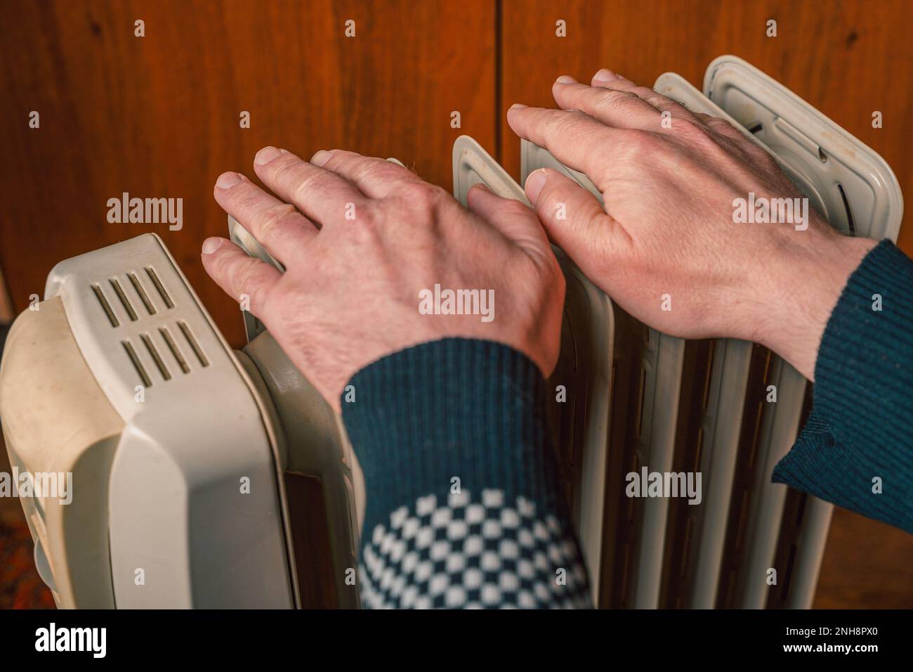 Mans Hand And Electric Heater Close Up Man Warming His Hands Over An
