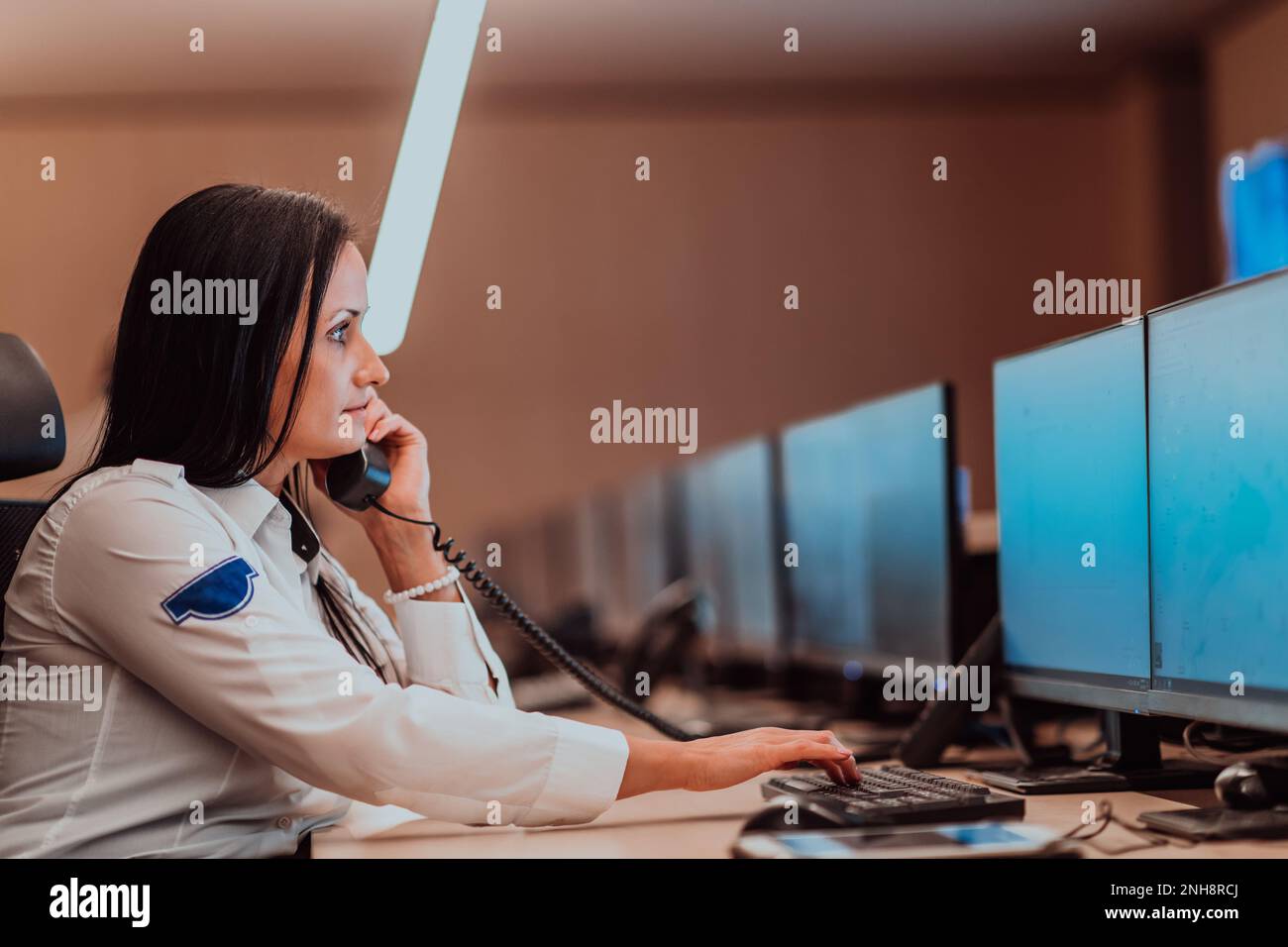 Female security operator working in a data system control room offices ...