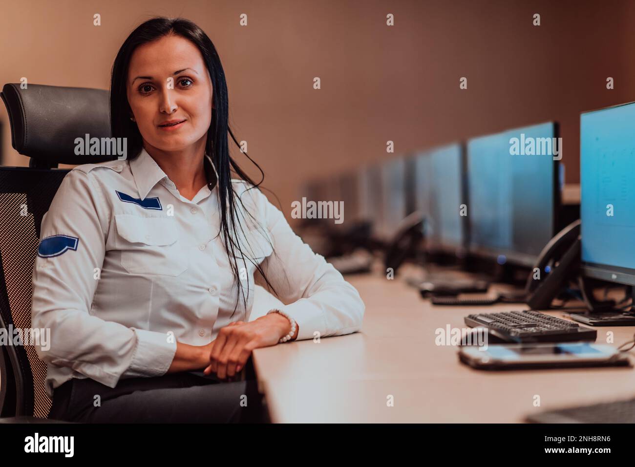 Female security operator working in a data system control room offices ...