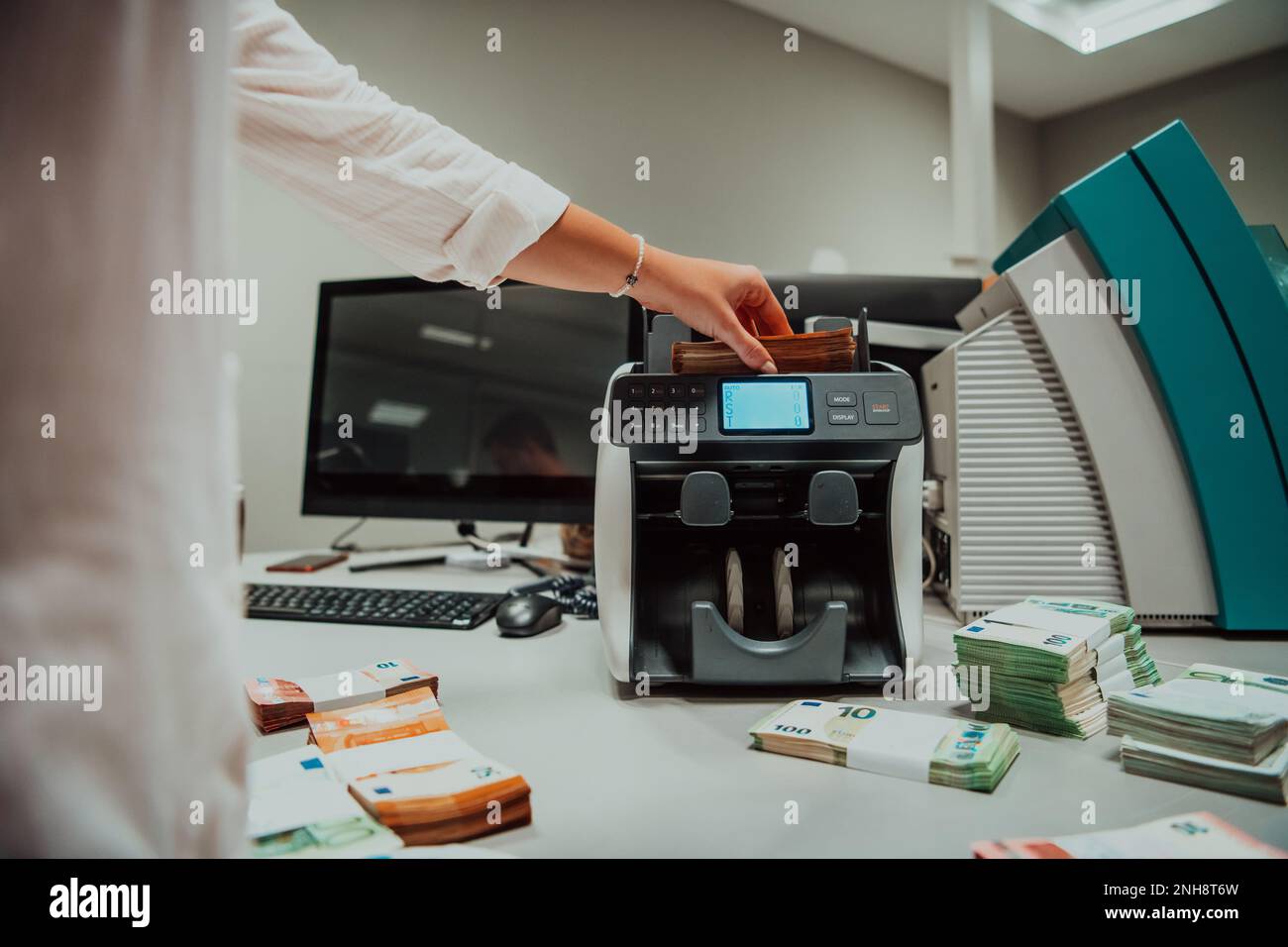 Bank employees using money counting machine while sorting and counting ...
