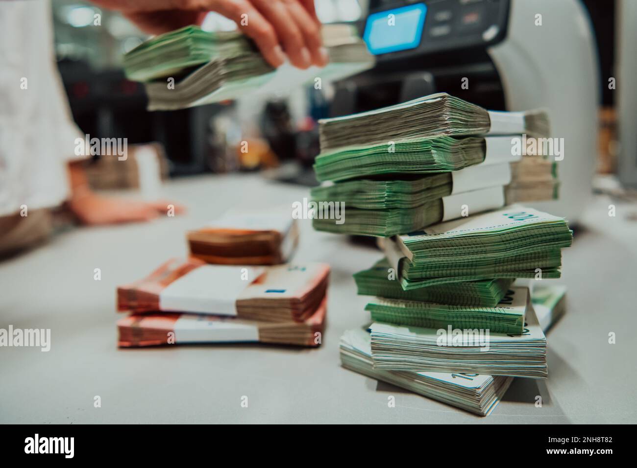 Bank employees using money counting machine while sorting and counting ...