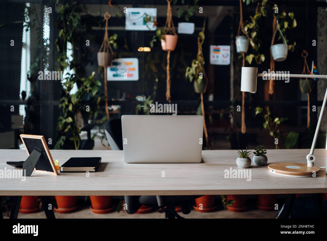 Wooden table with computer laptop, frame, lamp with sun light shine ...