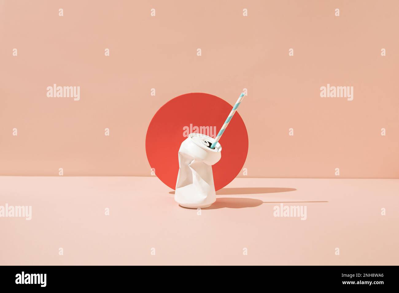 White crushed coda or beer can with paper straw and red circle in ...