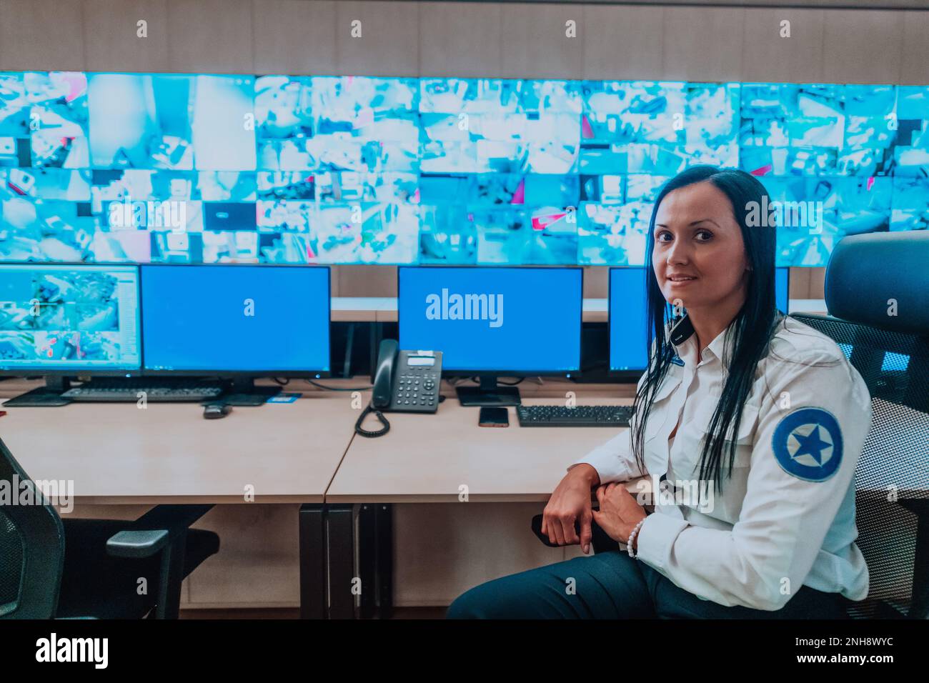 Female security operator working in a data system control room offices ...