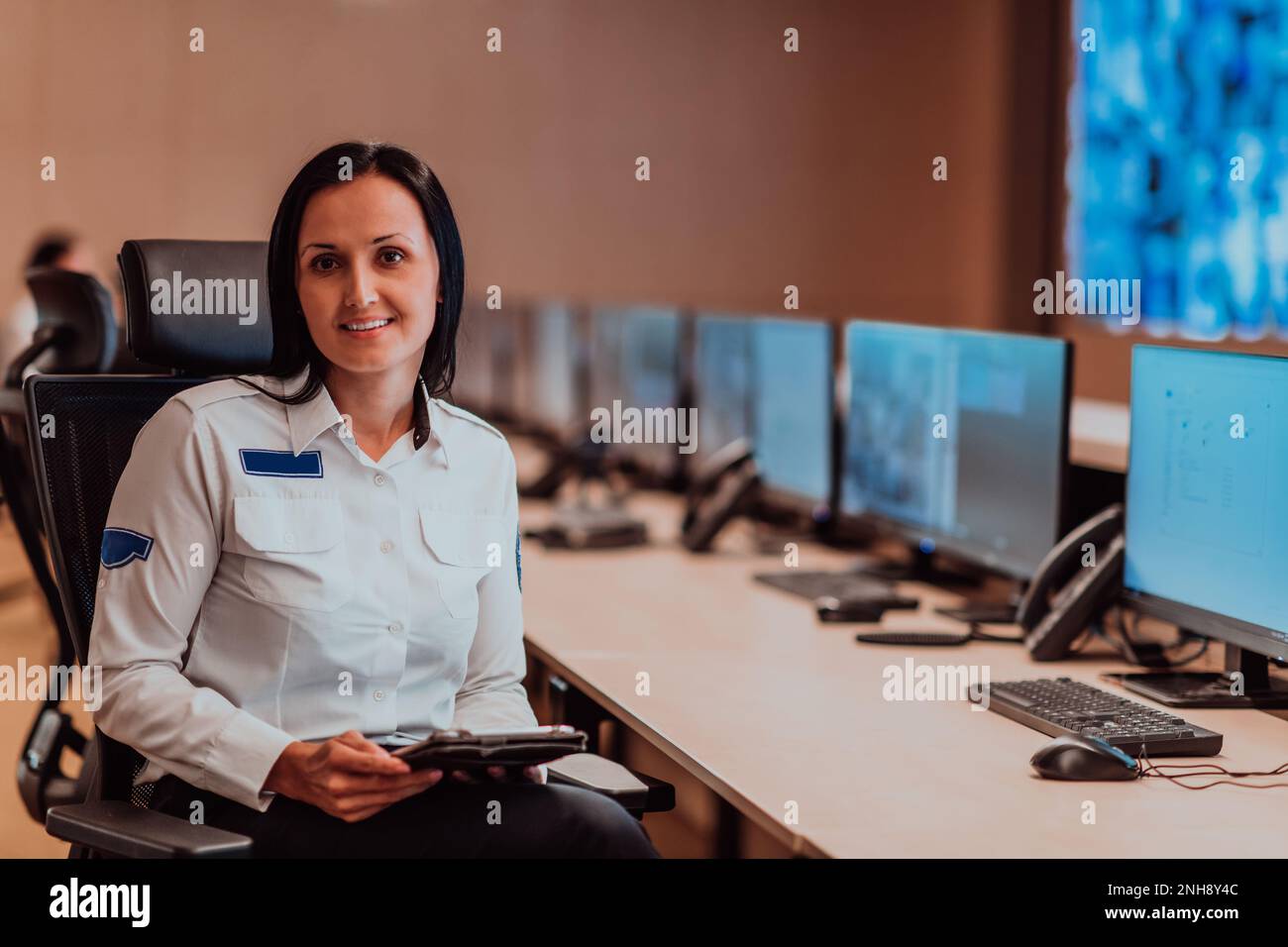 Female security operator working in a data system control room offices ...