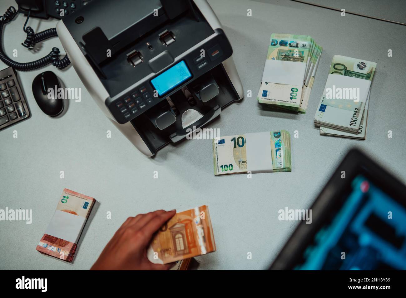 Bank employees using money counting machine while sorting and counting ...