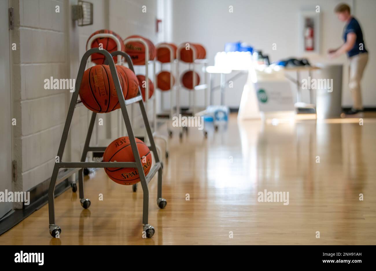 Racks of basketballs are lined against the Fitness Center wall in ...