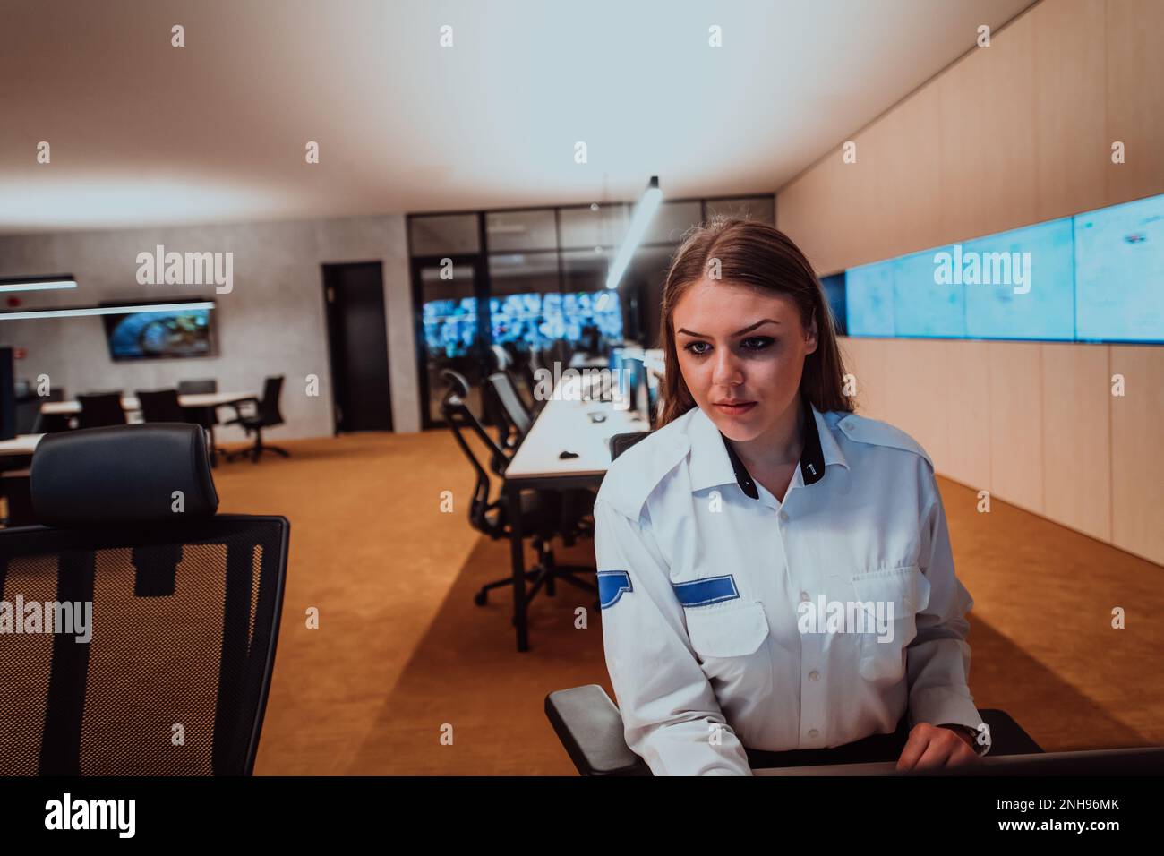 Female security operator working in a data system control room offices ...