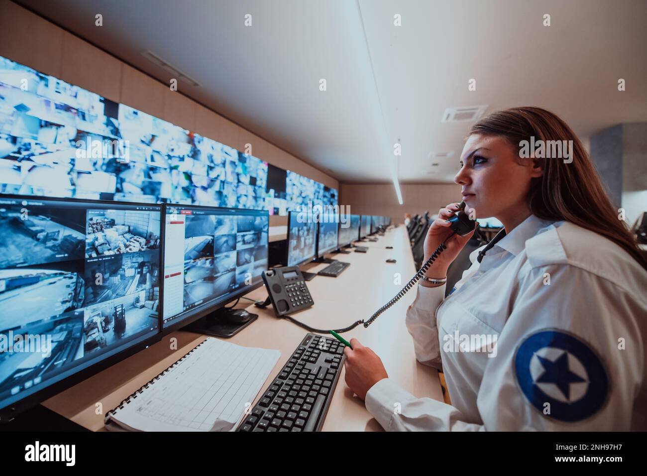 Female security operator working in a data system control room offices ...