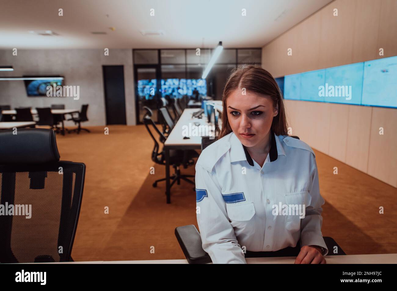 Female security operator working in a data system control room offices ...