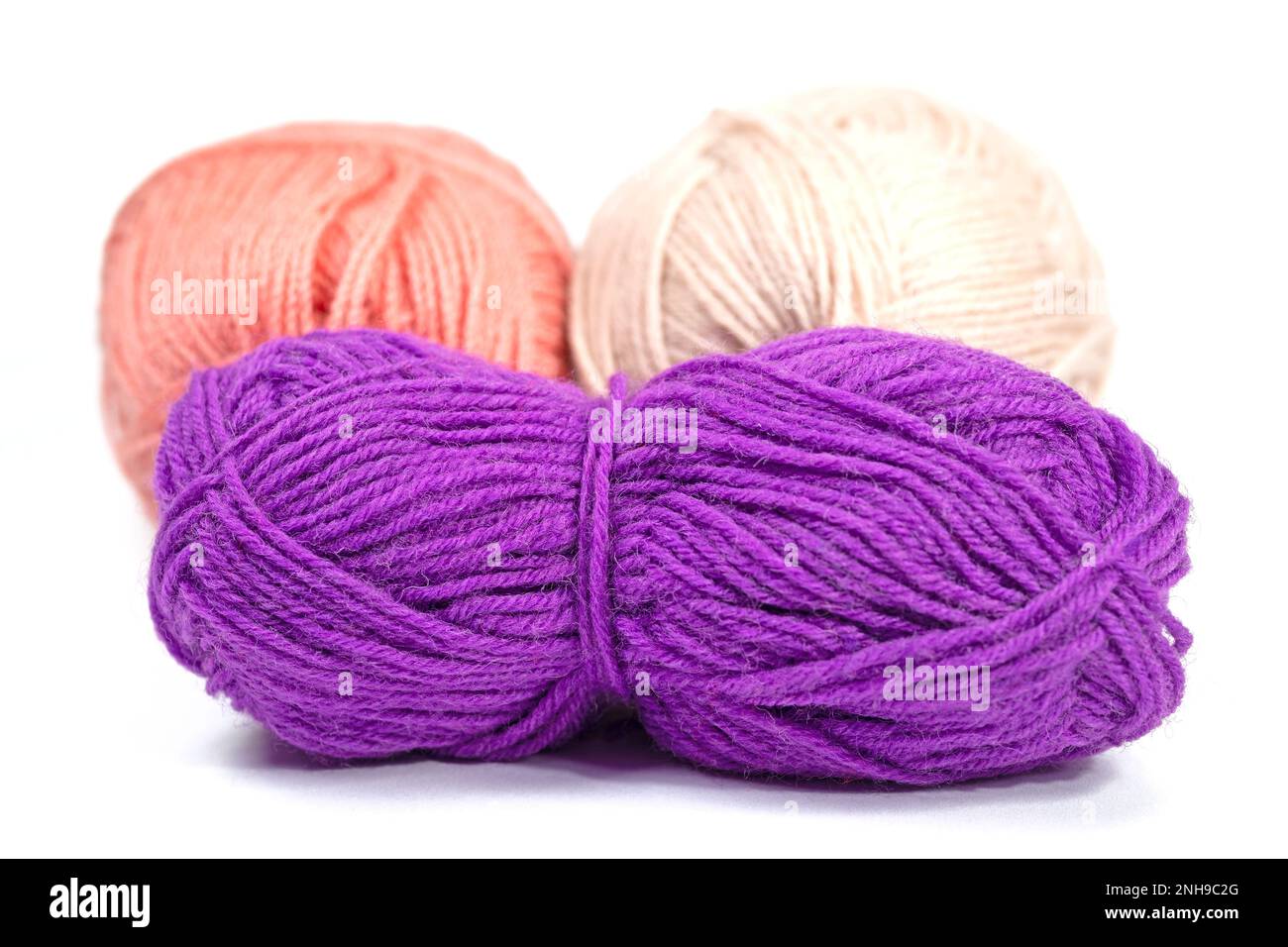 Purple knitting yarn against a white background Stock Photo - Alamy