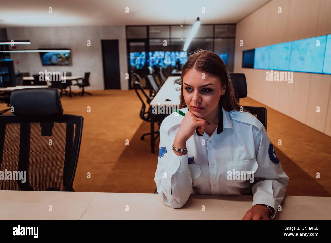 Female security operator working in a data system control room offices ...