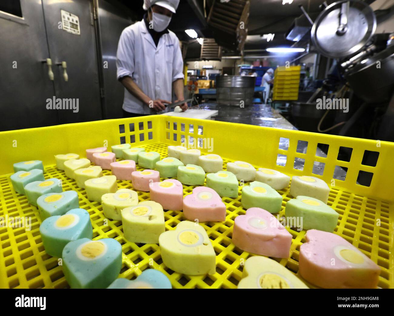 Workers of a seafood processing company cool down heart-shaped fish ...