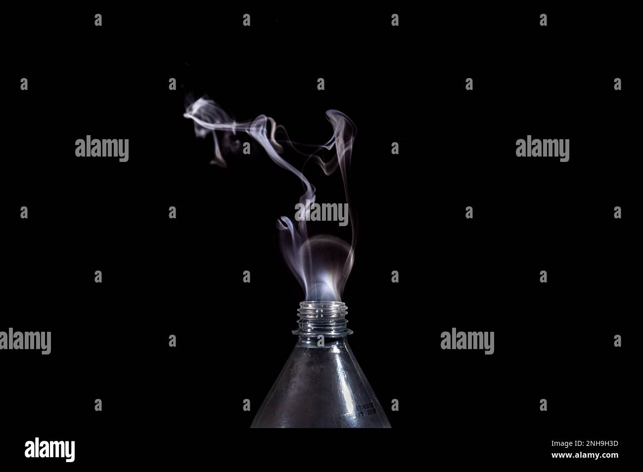 Moving smoke coming out of a plastic bottle. Isolated on black ...