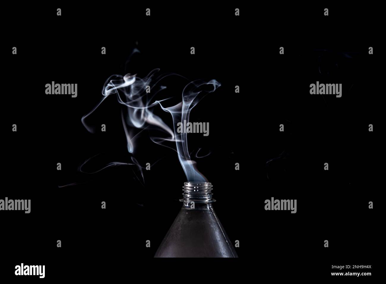 A transparent plastic bottle, isolated, with smoke coming out of the ...