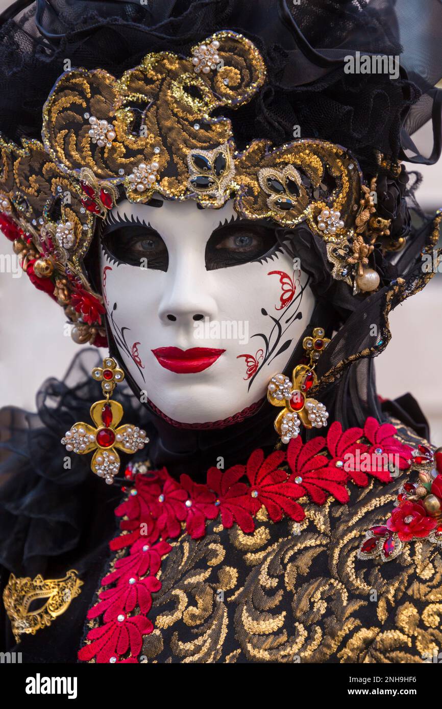 Carnival goer dressed in splendid red and gold coloured costume and ...