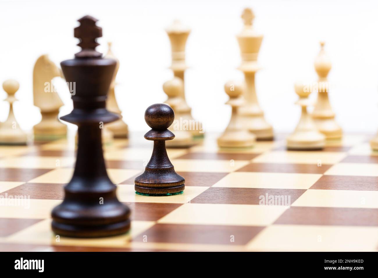 moving black pawn and queen against white chess pieces in background on ...