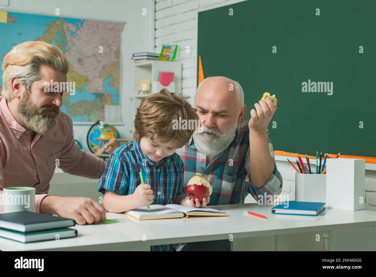 Grandfather father and son learning to write and read, men in different ...