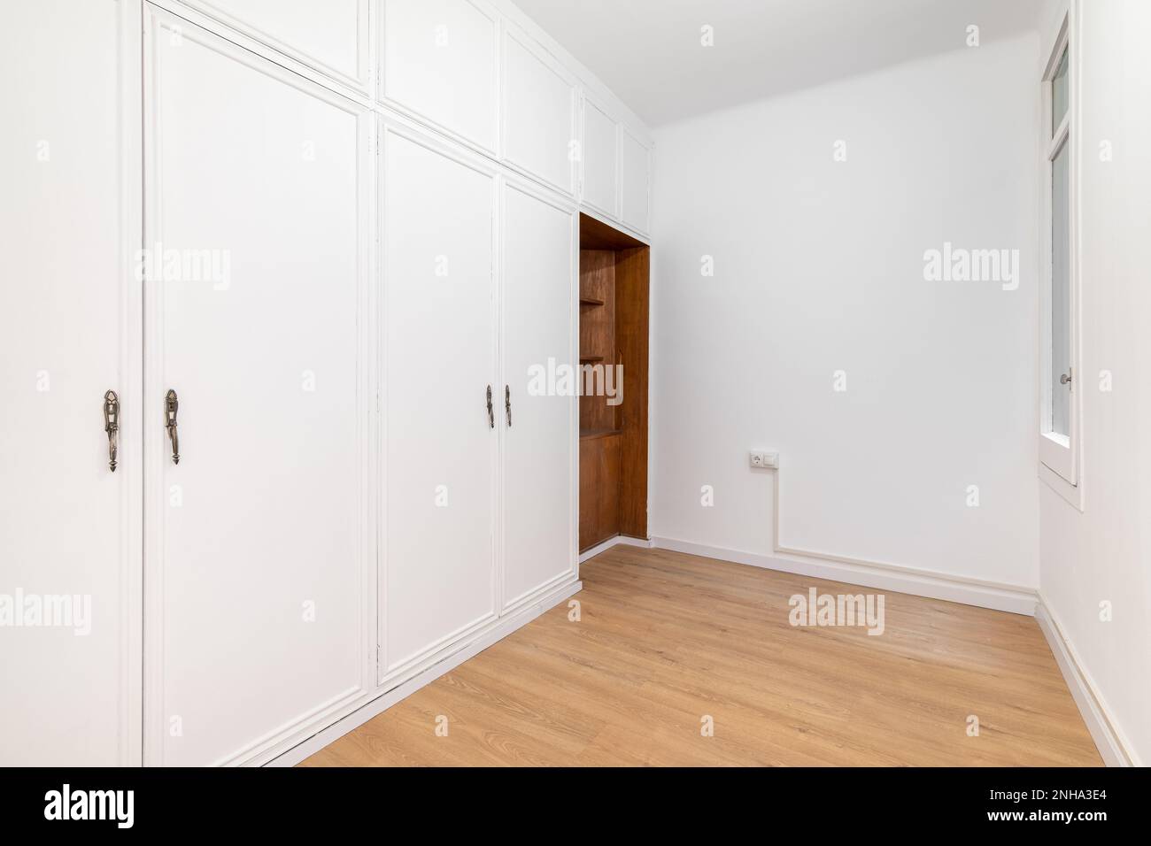 Built-in spacious wardrobes in a room with wooden laminate flooring ...
