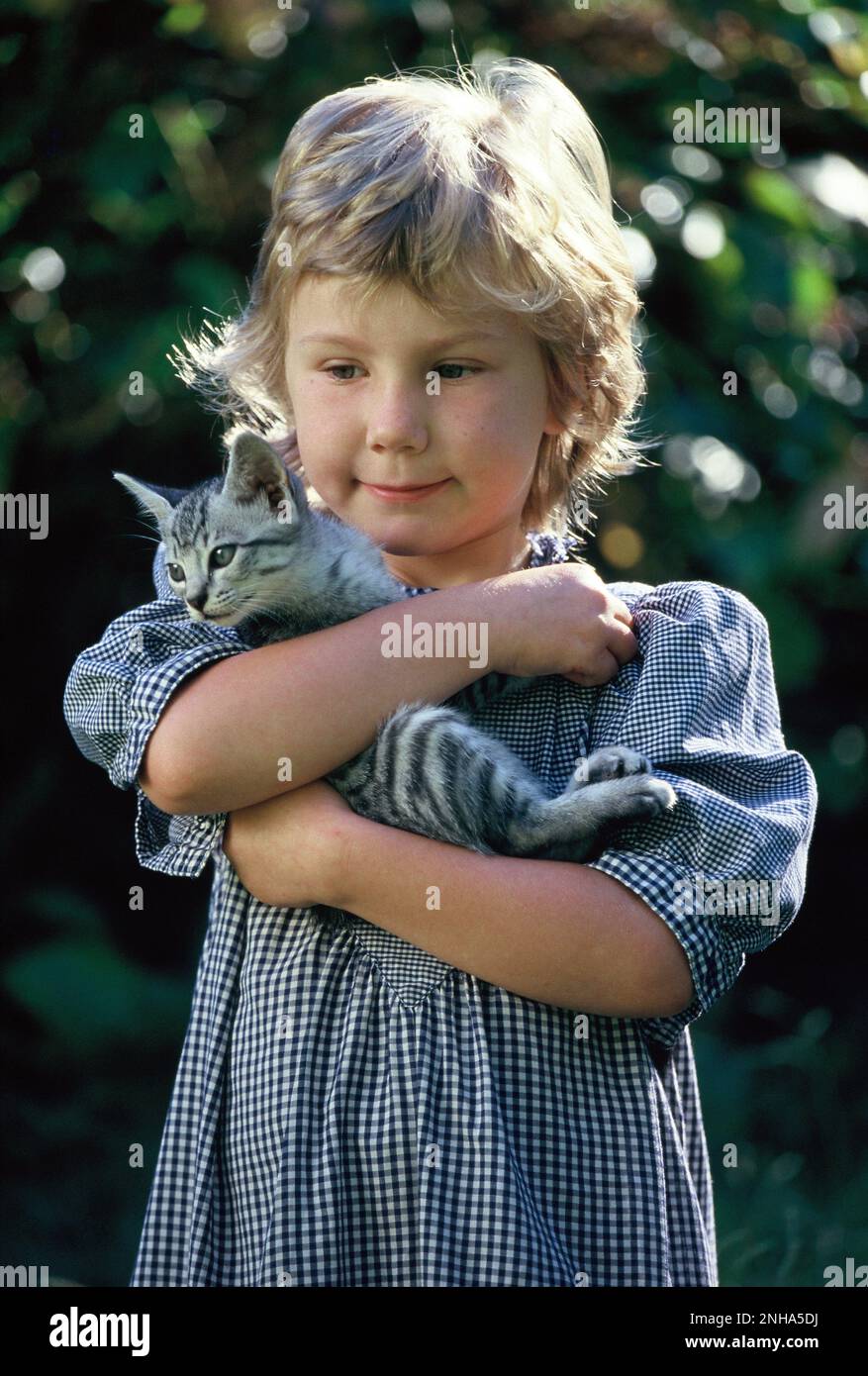 Children. Little girl outdoors in garden holding her pet cat Stock ...
