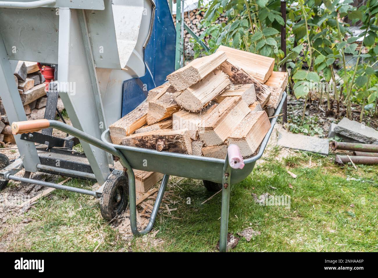 Close up of a wheelbarrow fully loaded with logs working and sawing ...