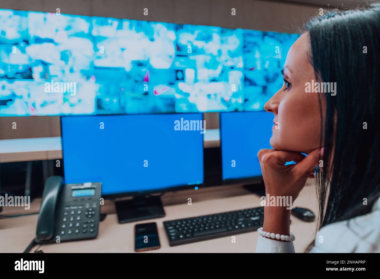 Female security operator working in a data system control room offices ...