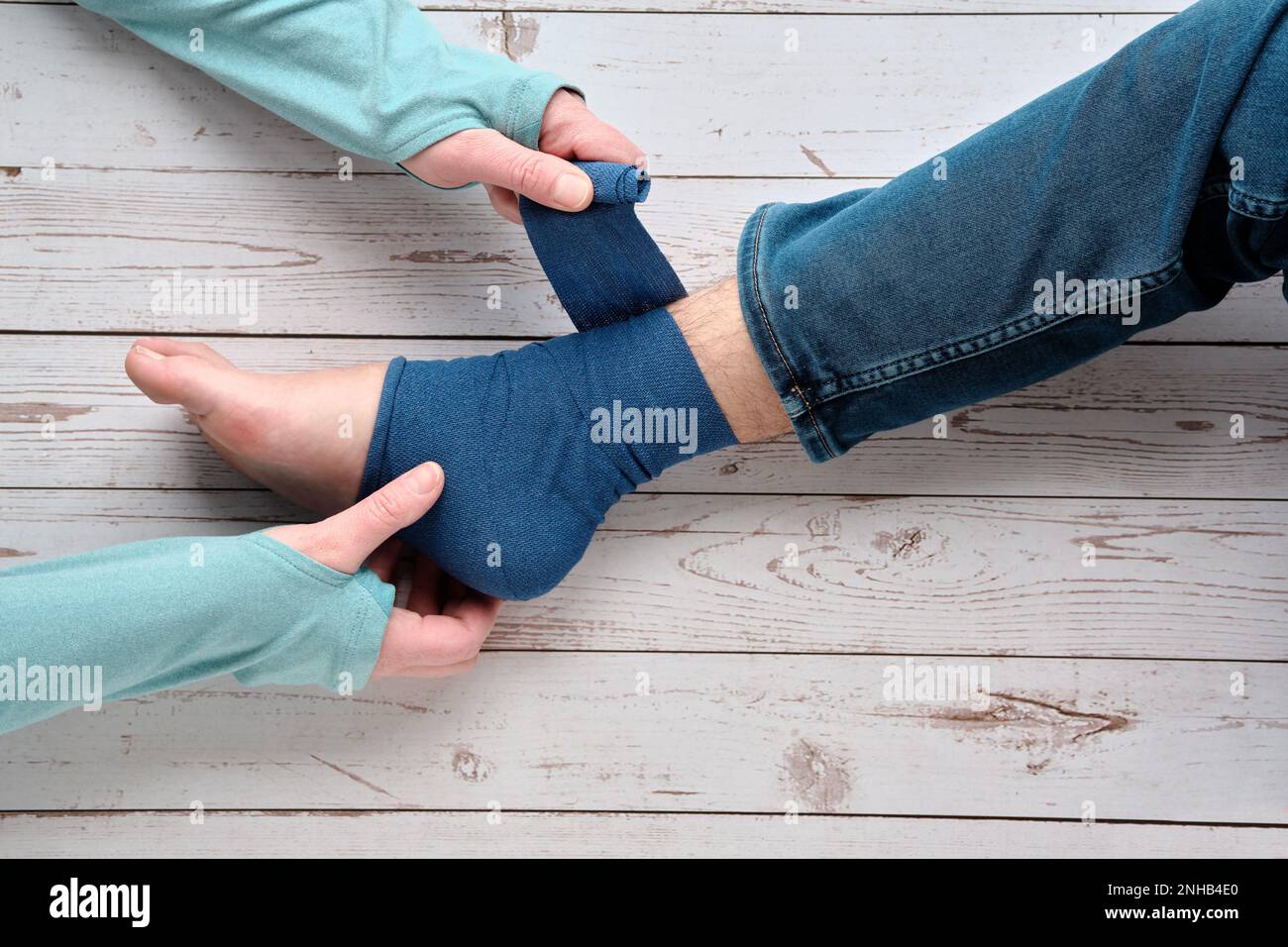 Feet trauma, injury. Adult wrapping compression bandage around sprained ...