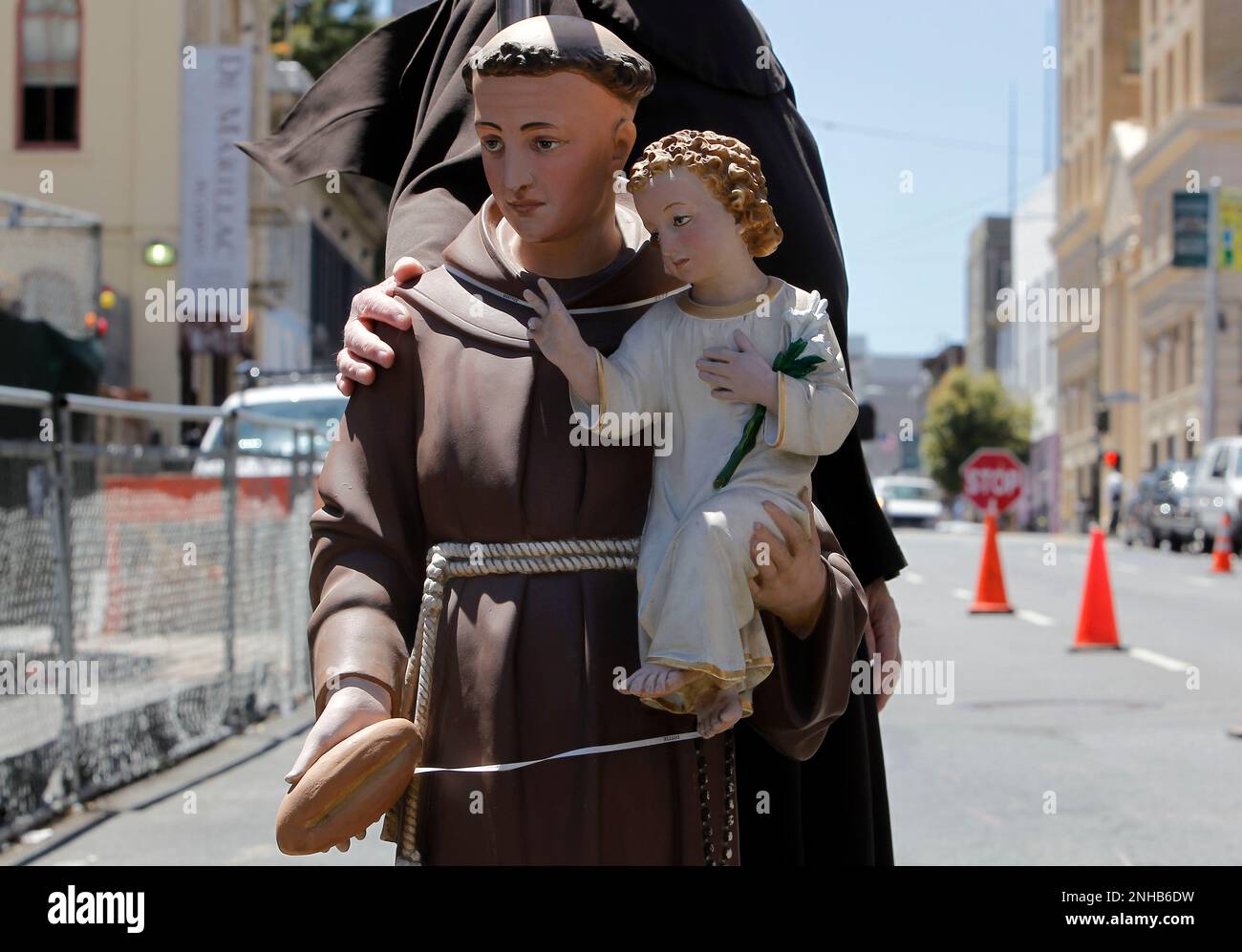 Father Tom West stands with his hand on the statue of St. Anthony as it ...