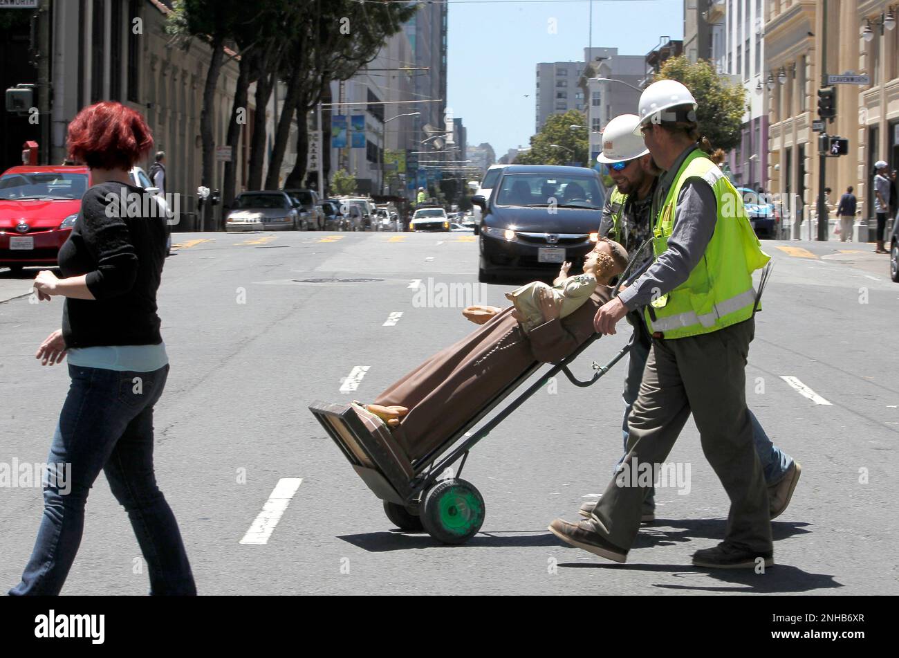 Workers Joe Lenz and Manuel Brito wheel the statue of St. Anthony down ...