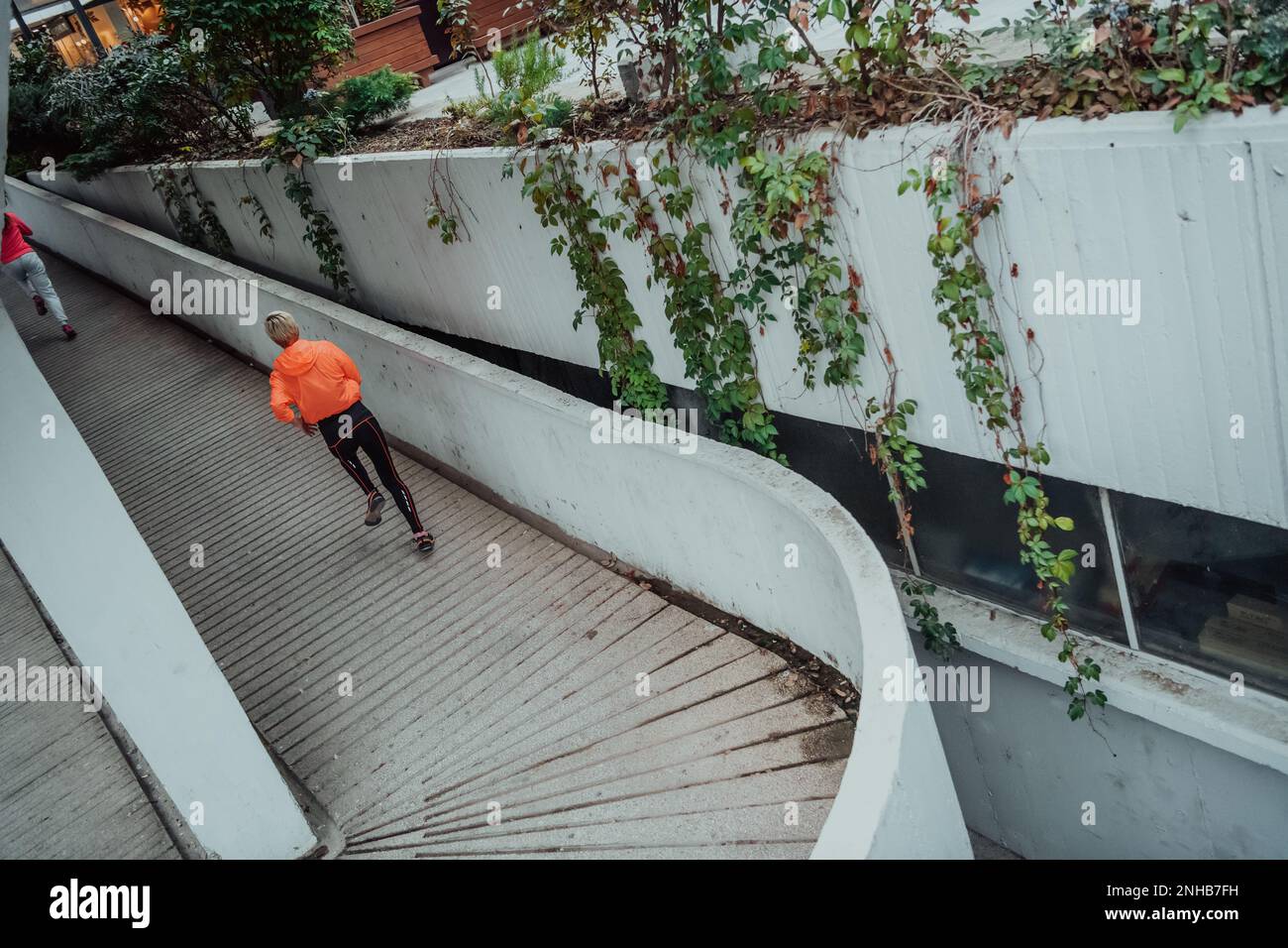 Two women in sports clothes running in a modern urban environment. The ...