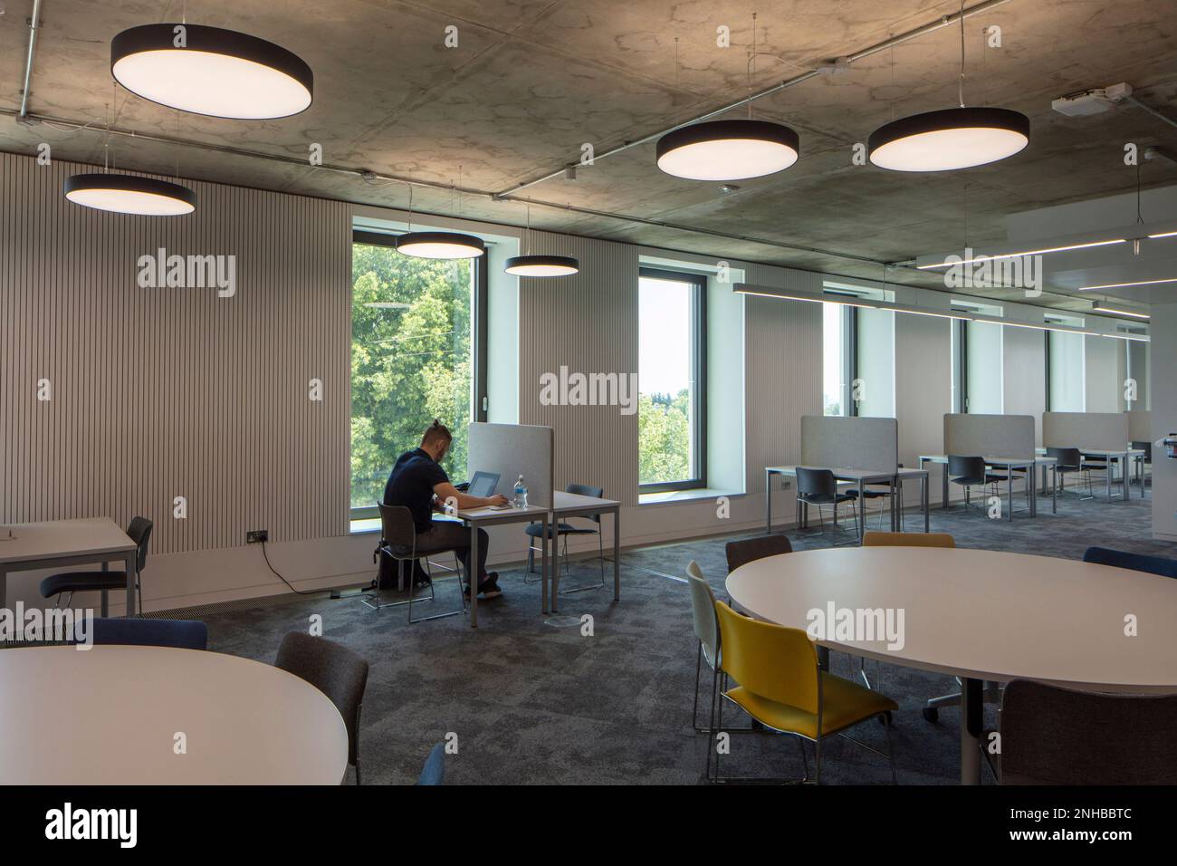 A student working at a desk in one of the communal work ares. Centenary ...