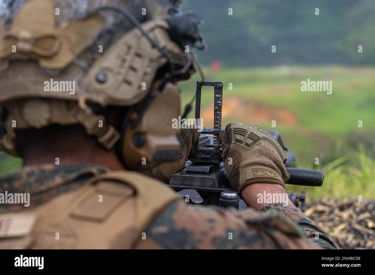 A U.S. Marine with 3d Battalion, 2d Marines adjusts the sight on an ...