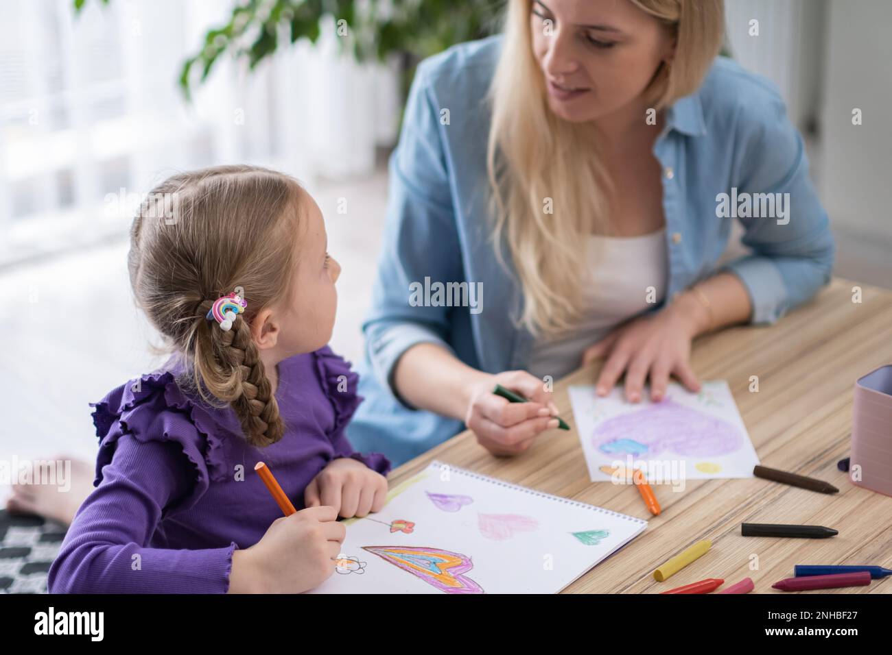 pre school art class for creativity. teacher helps to little girl to ...