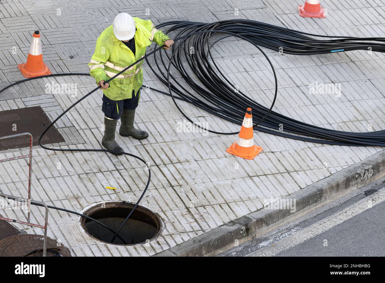 A worker is performing maintenance tasks on a communication cable ...