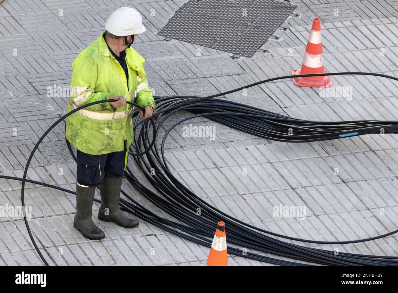 A worker is performing maintenance tasks on a communication cable ...