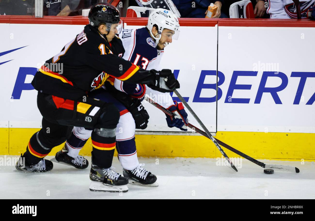 Columbus Blue Jackets forward Johnny Gaudreau, right, is checked by ...