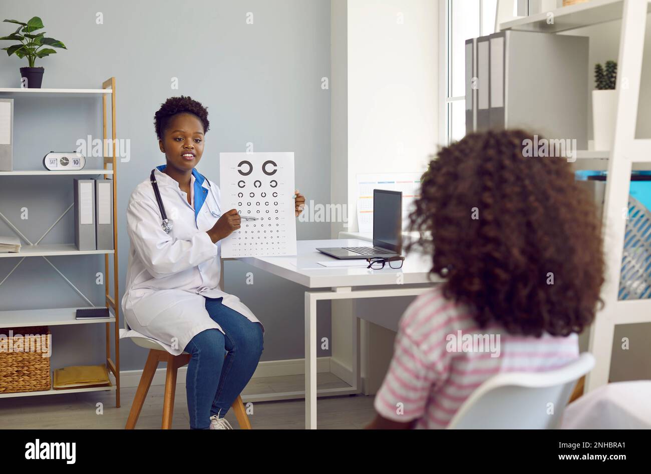 Female optometrist examines vision of child girl patient using vision ...