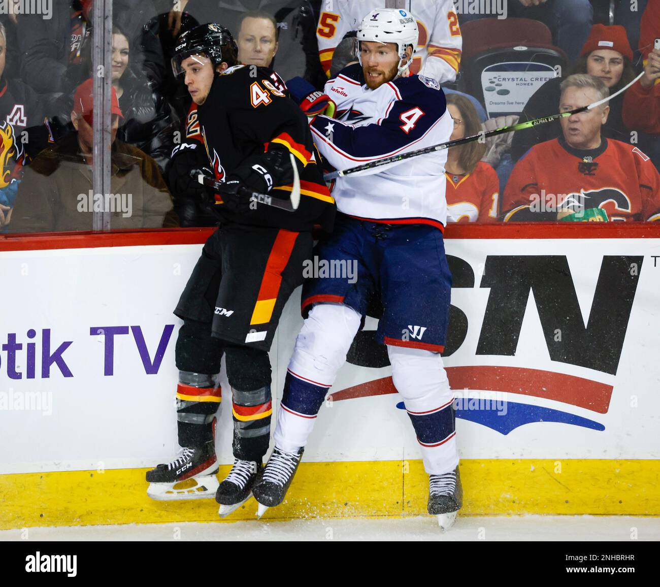 Columbus Blue Jackets defenseman Vladislav Gavrikov, right, is checked ...