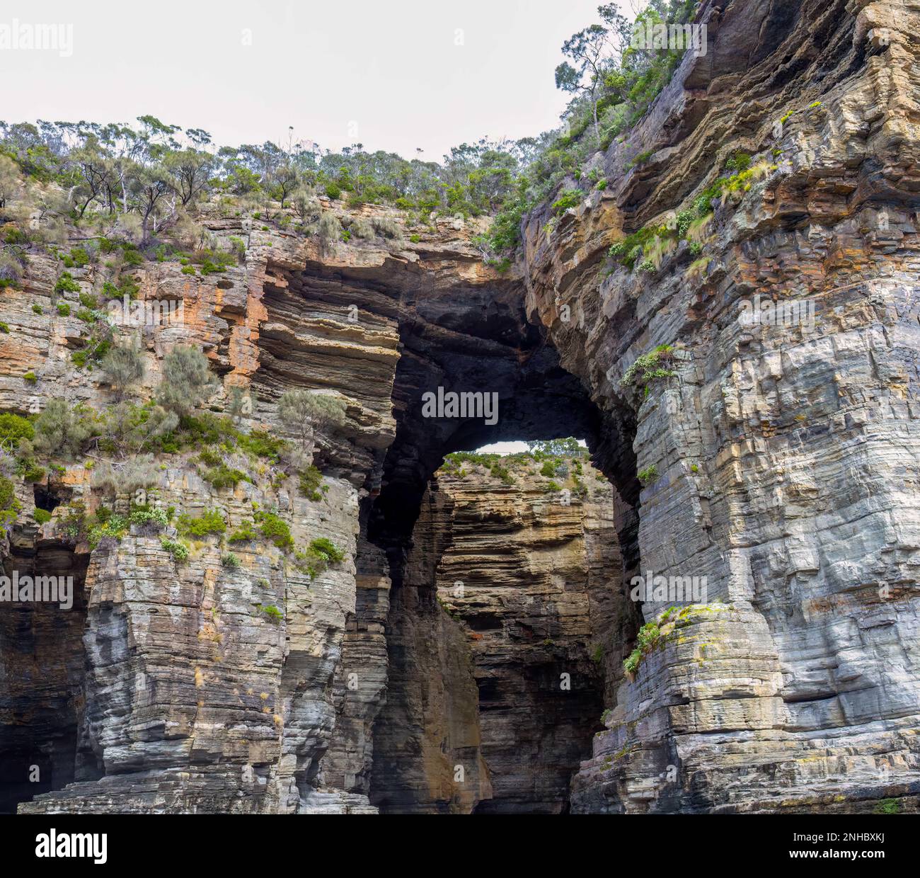 Arches in high cliffs along waterfront on the southern coastline of ...