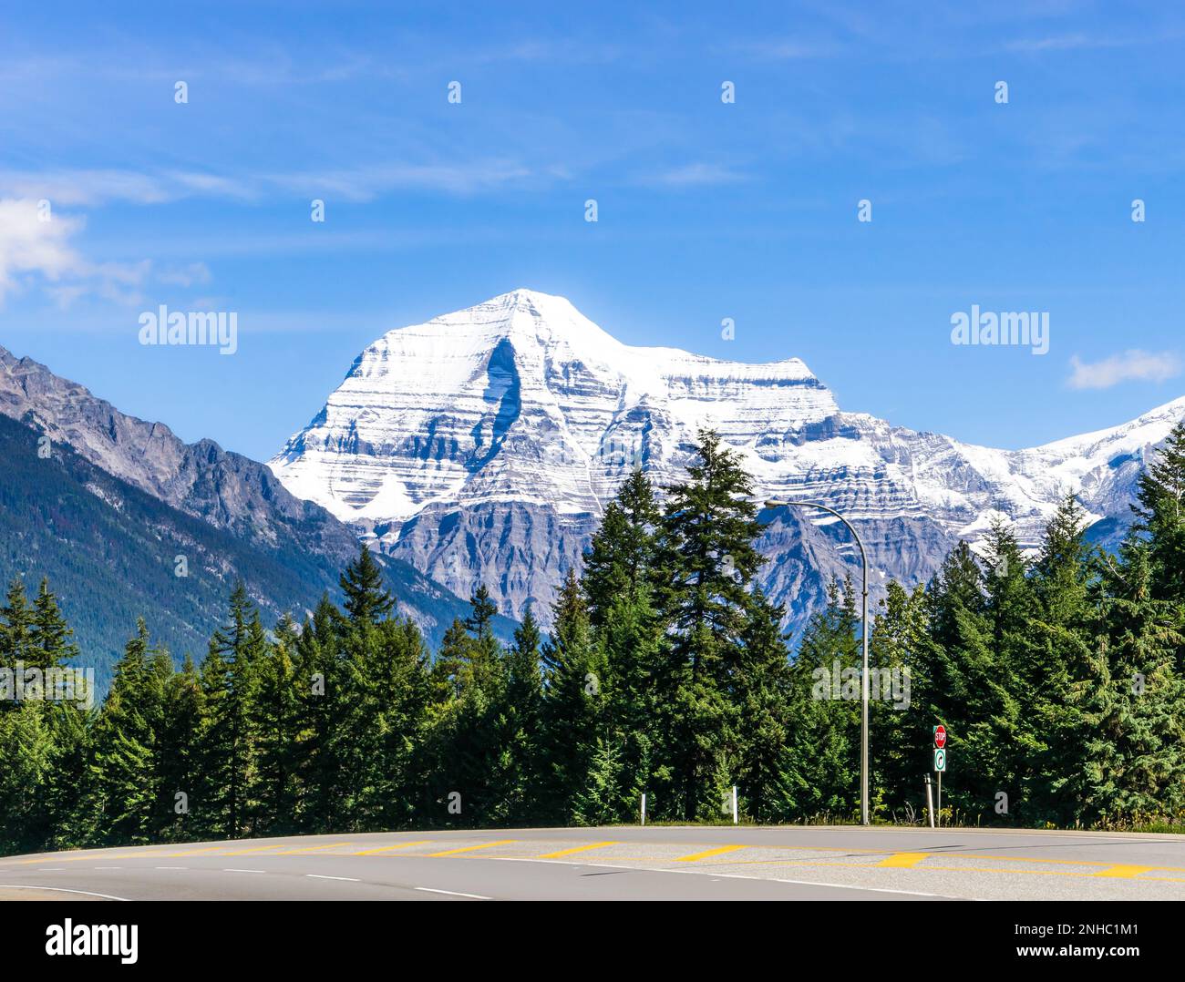 View to Mount Robson with slightly clouded blue sky and highway and ...