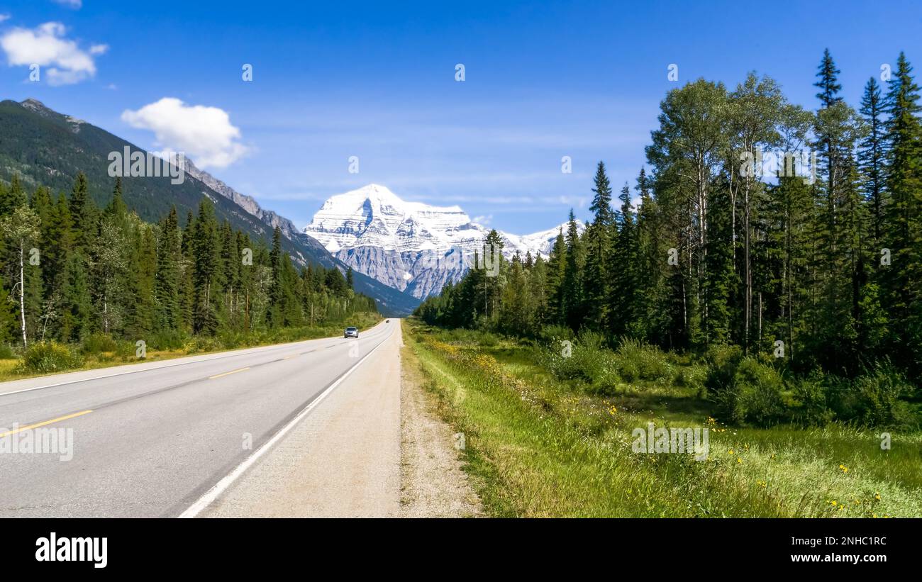 Road leads to to Mount Robson with slightly clouded blue sky and ...