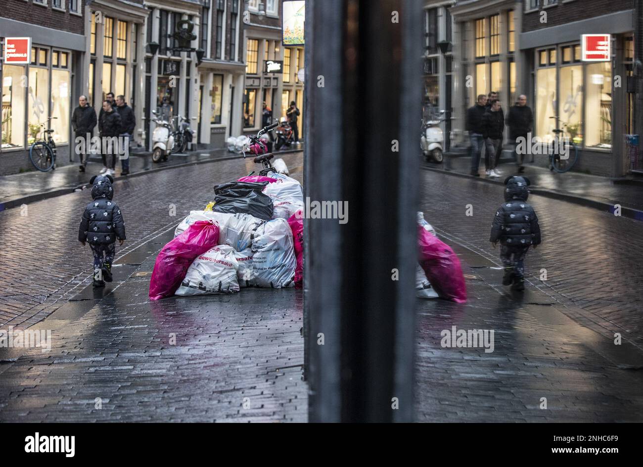 AMSTERDAM - Tourists walk past the garbage during a strike by municipal ...